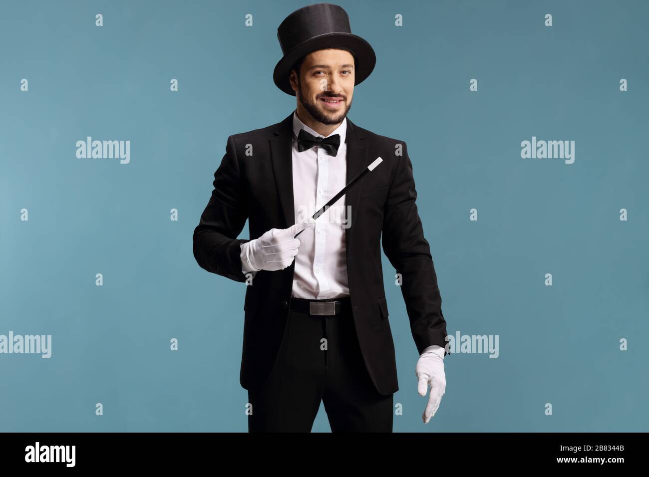 Magician holding a magic wand isolated on blue background Stock Photo ...