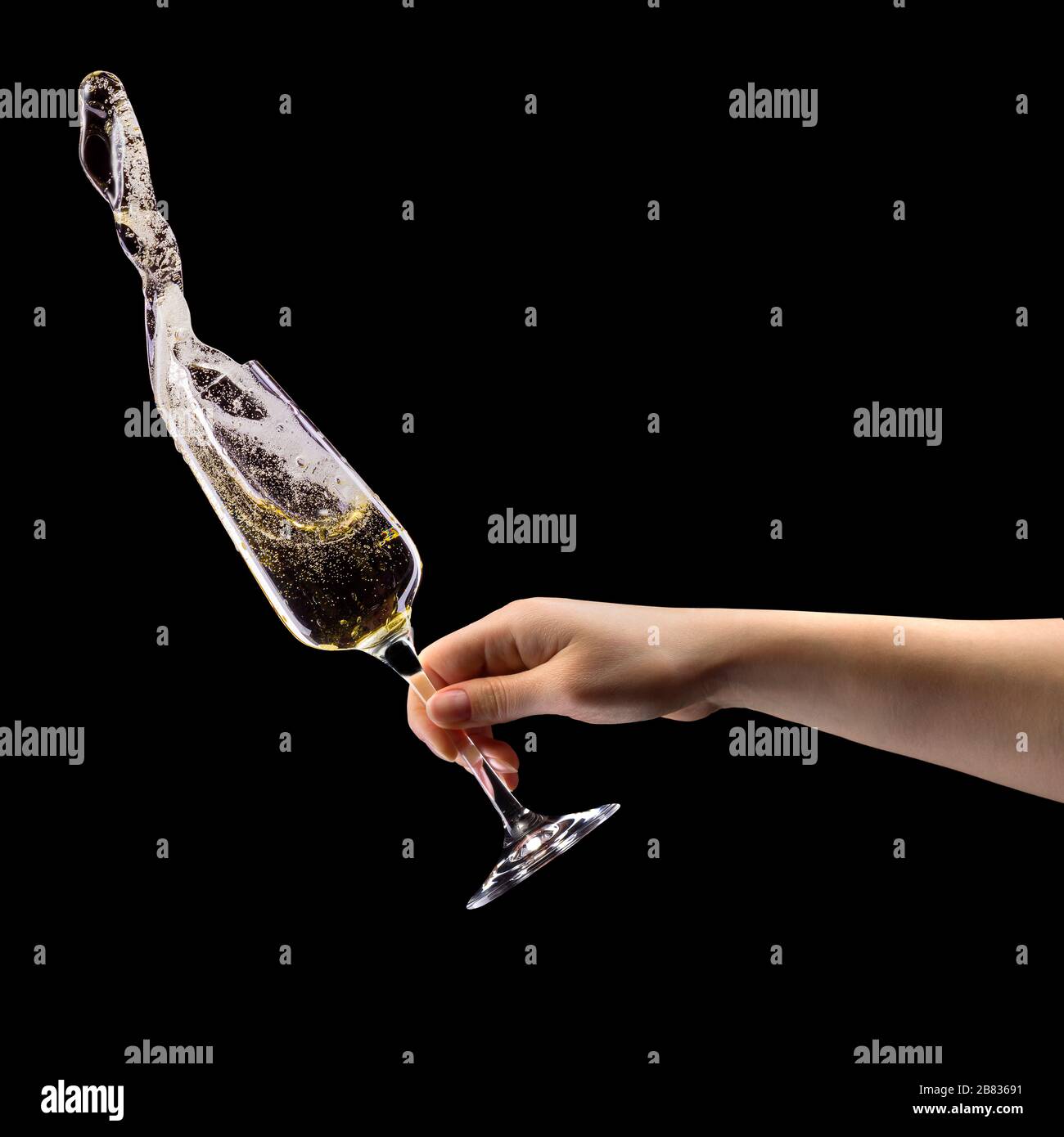 Woman hand holding glass of sparkling champagne with splashes isolated ...