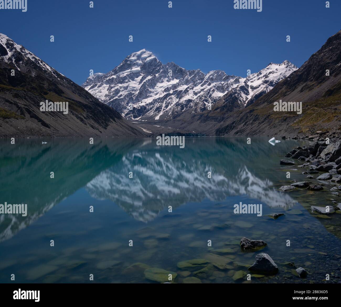 Reflection of snow capped mountain in glacial lake, Mount Cook Stock ...