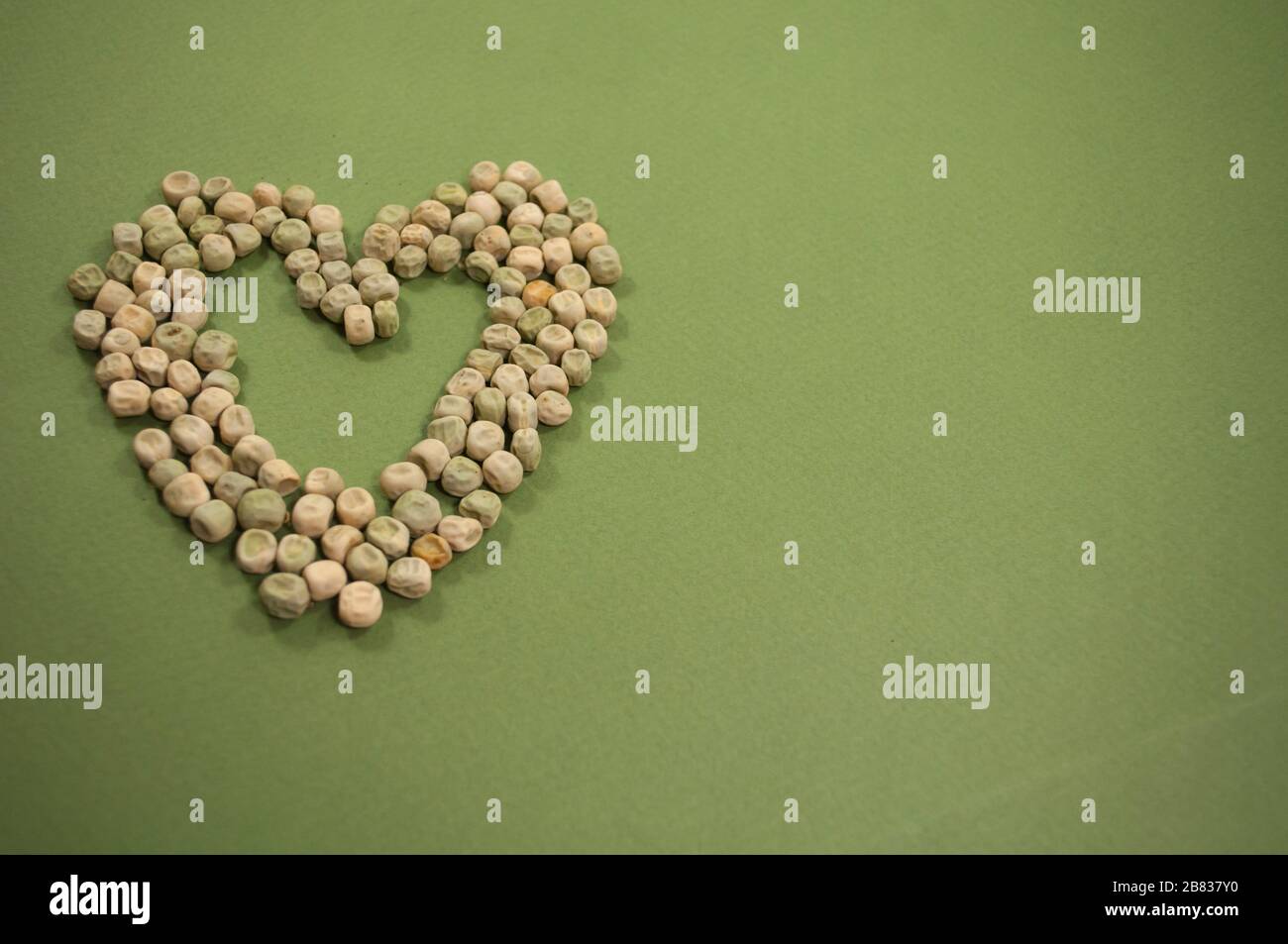Heart shape with dried pea seeds on green background Stock Photo - Alamy