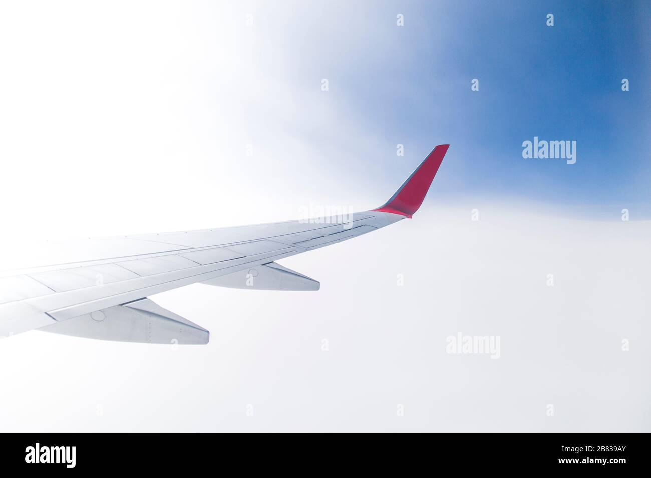 Empty airplane wing view via passenger window with blue sky, clean and ...