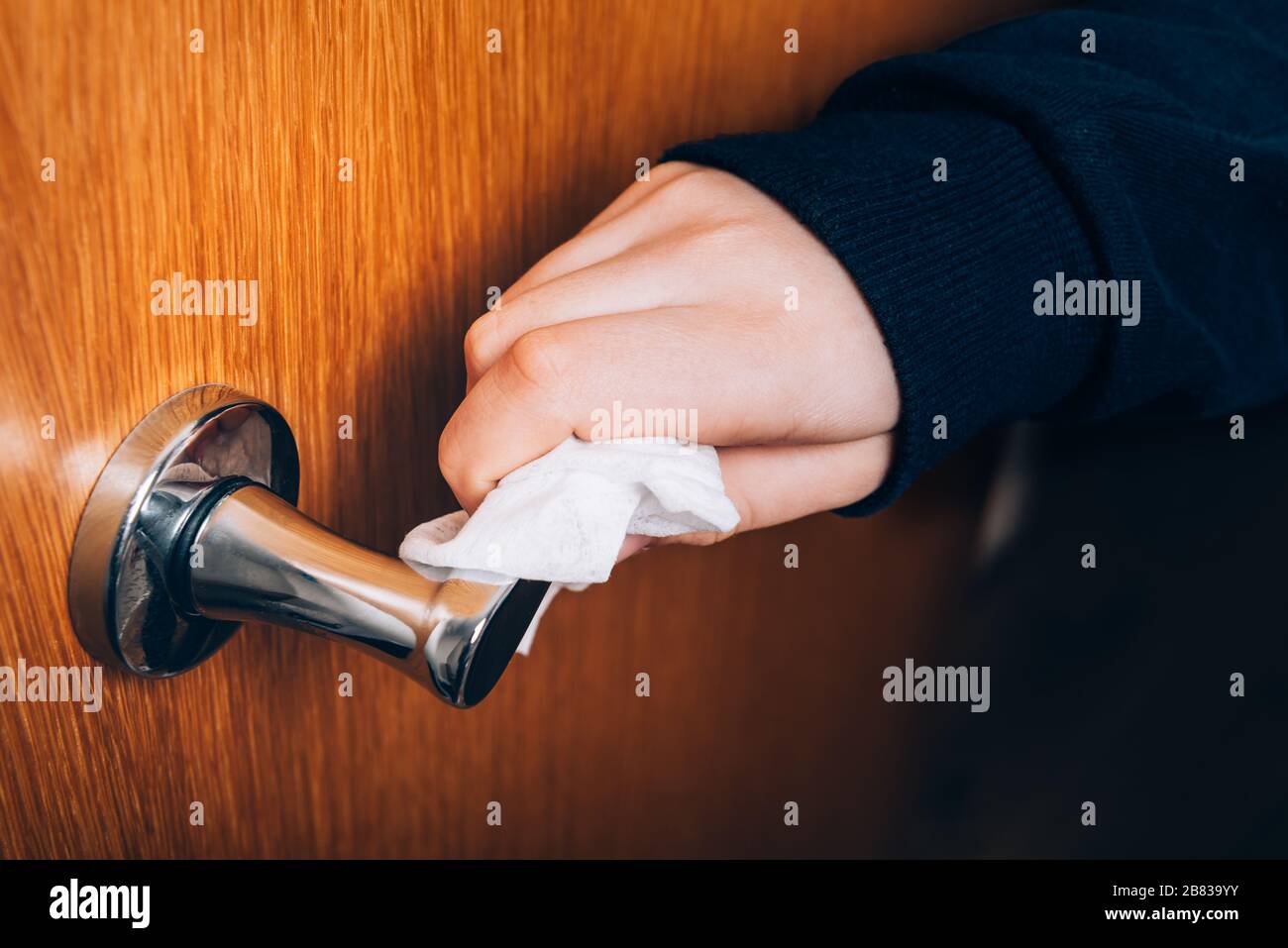 Hands wipe the door handle with disinfectant cloth. Necessary method to ...