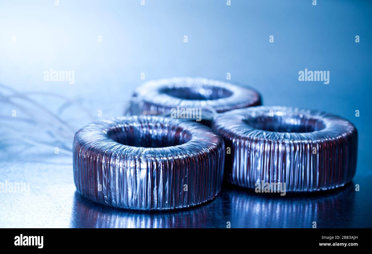 Close-up round transformer wrapped in wire lie on the table on top of ...