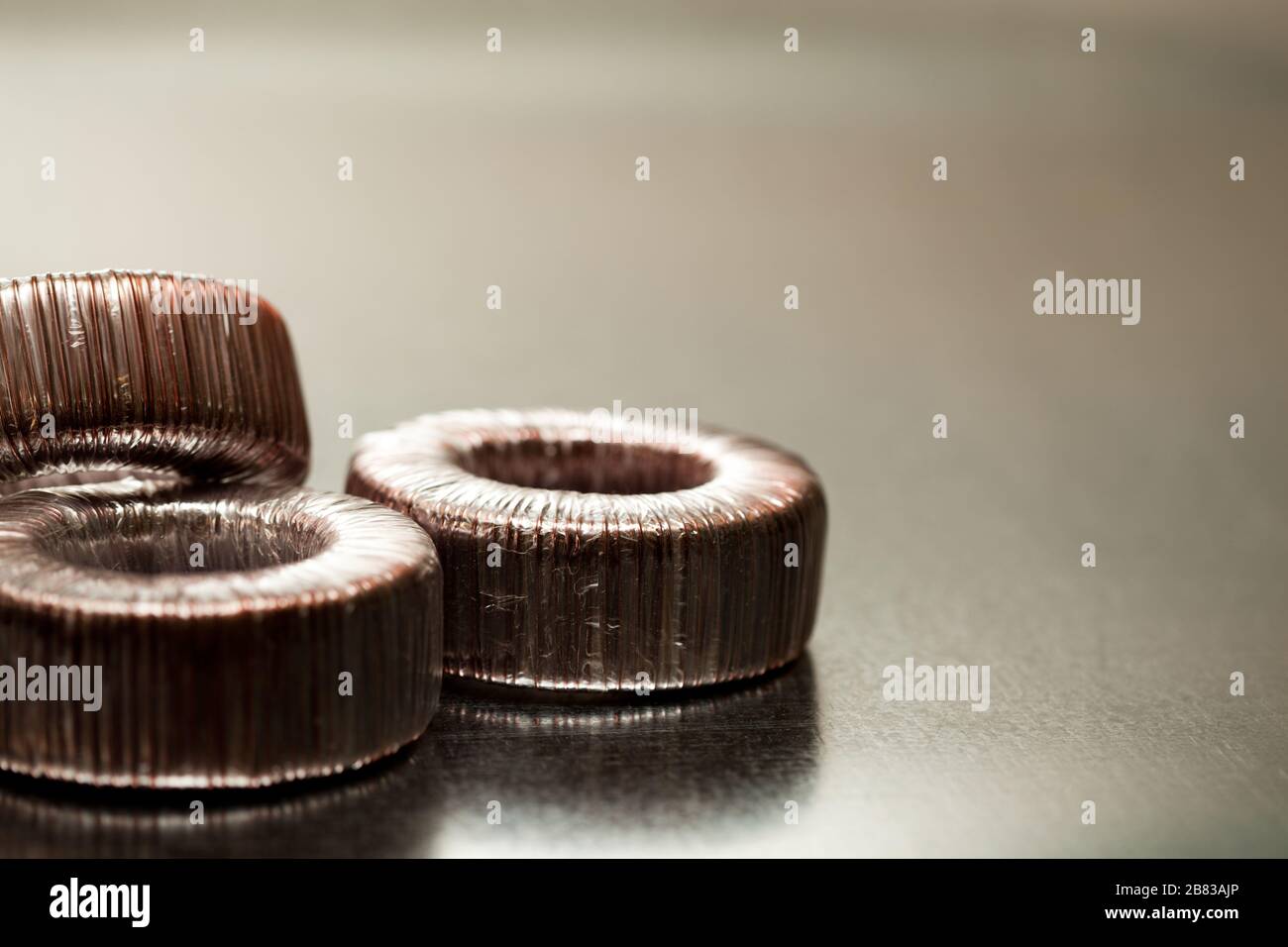Close-up round transformer wrapped in wire lie on the table on top of ...