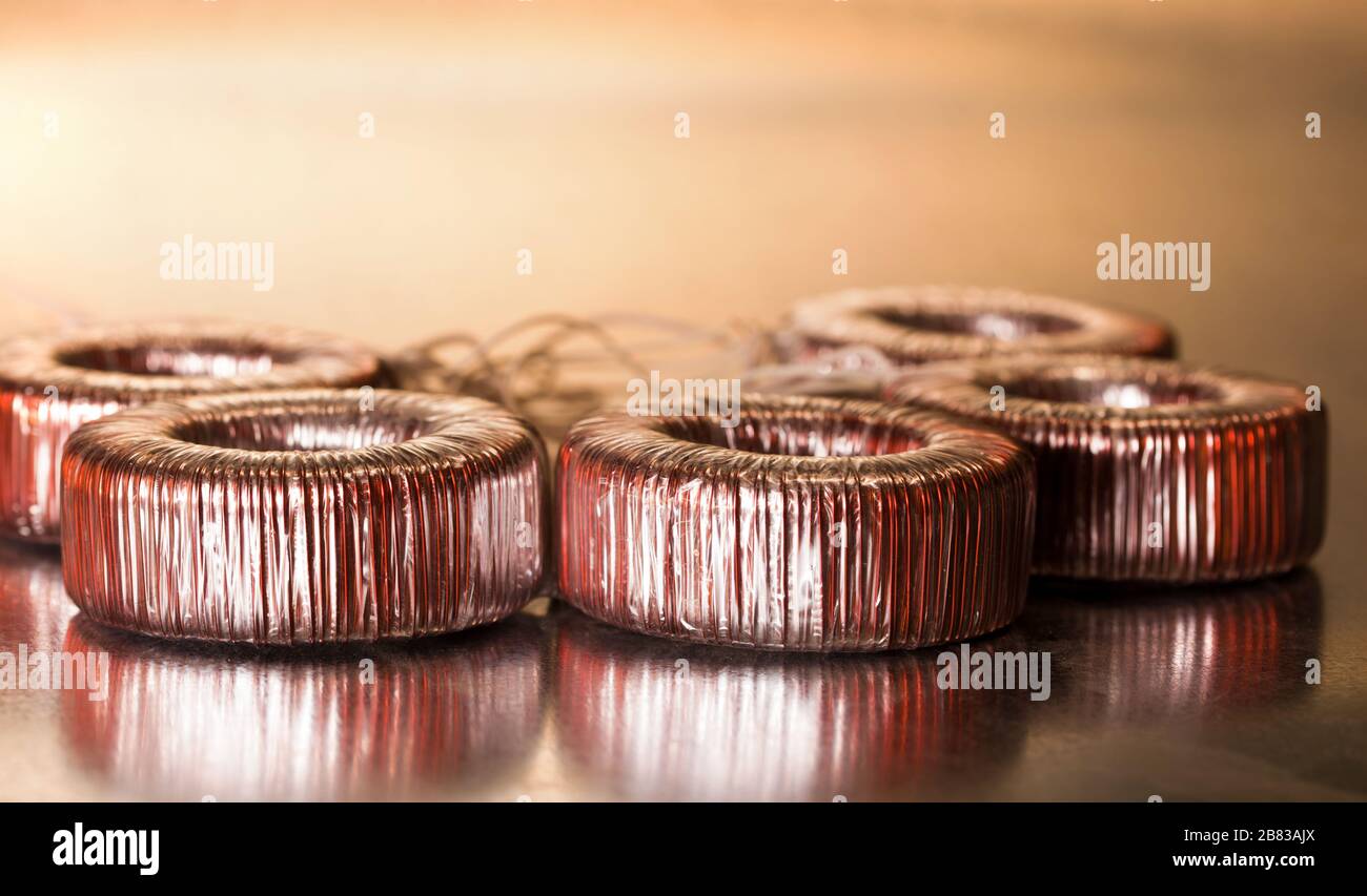 Close-up round transformer wrapped in wire lie on the table on top of ...