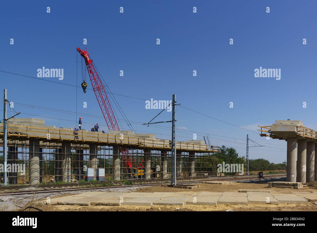 Workers at the construction of an elevated bridge crossing the railway ...