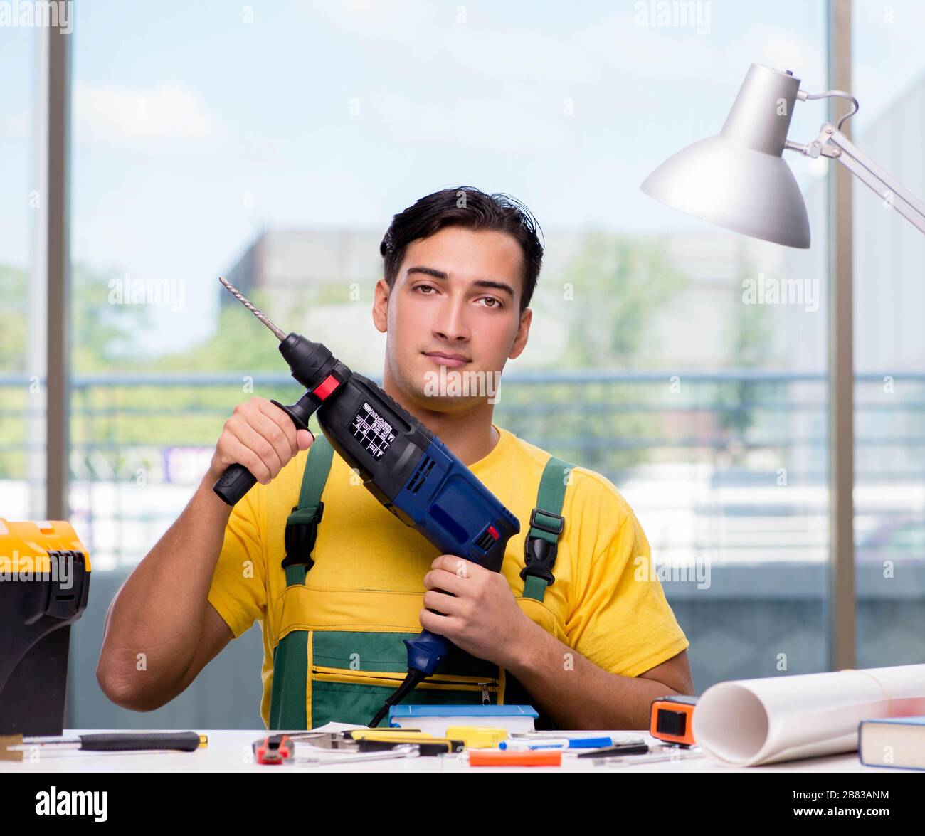 The construction worker sitting at the desk Stock Photo - Alamy