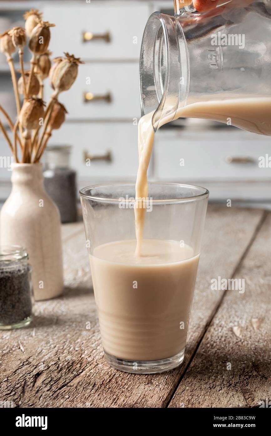 Pouring poppy seed milk into a glass Stock Photo - Alamy