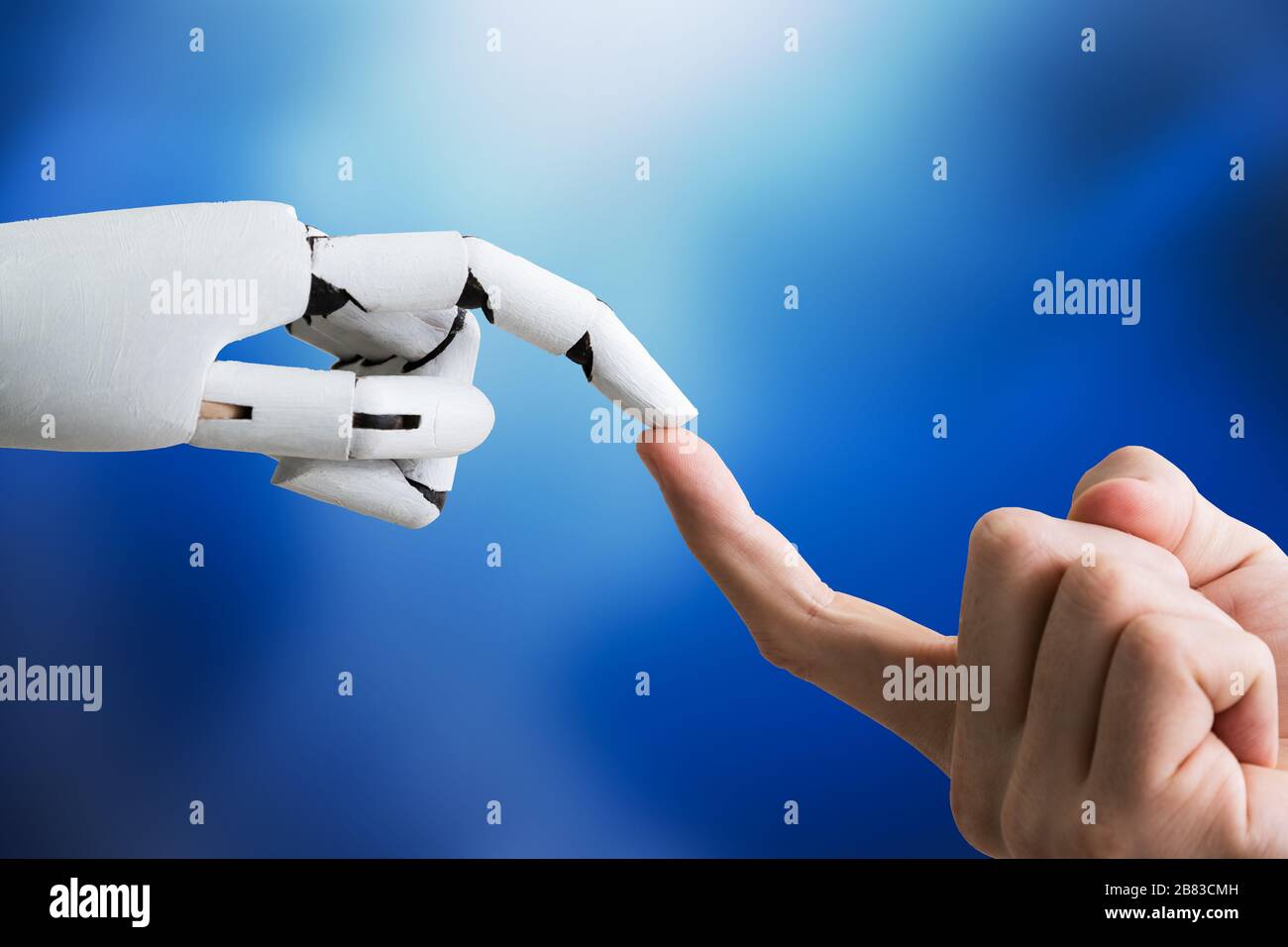 Close-up Of Businessperson Finger Touching Robotic Finger Over White ...