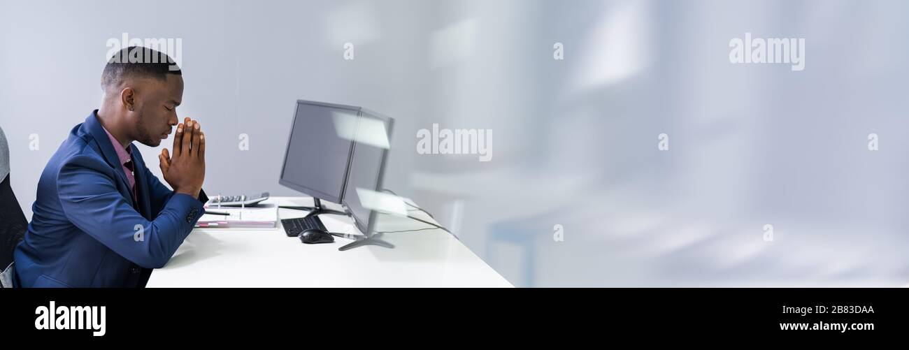 African Man Praying At Work In Office Stock Photo - Alamy