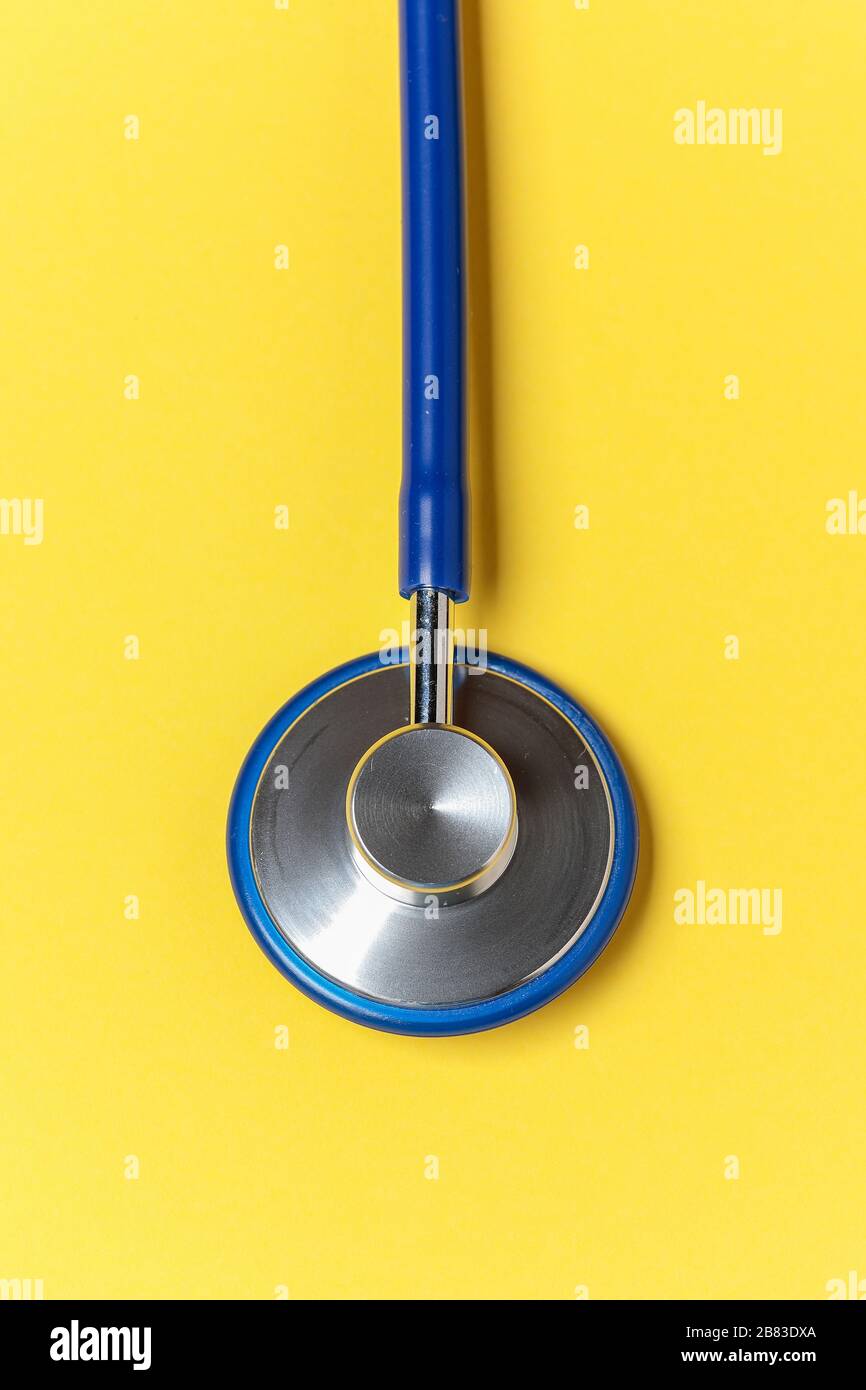 vertical view of the bell of a blue stethoscope on foreground isolated ...