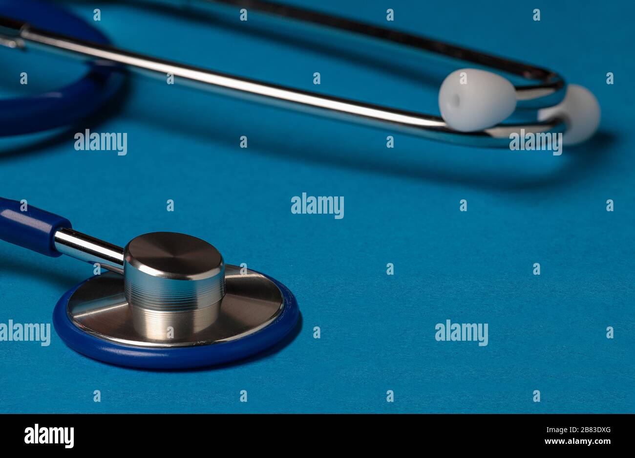 vertical view of an stethoscope with the bell on foreground on blue ...