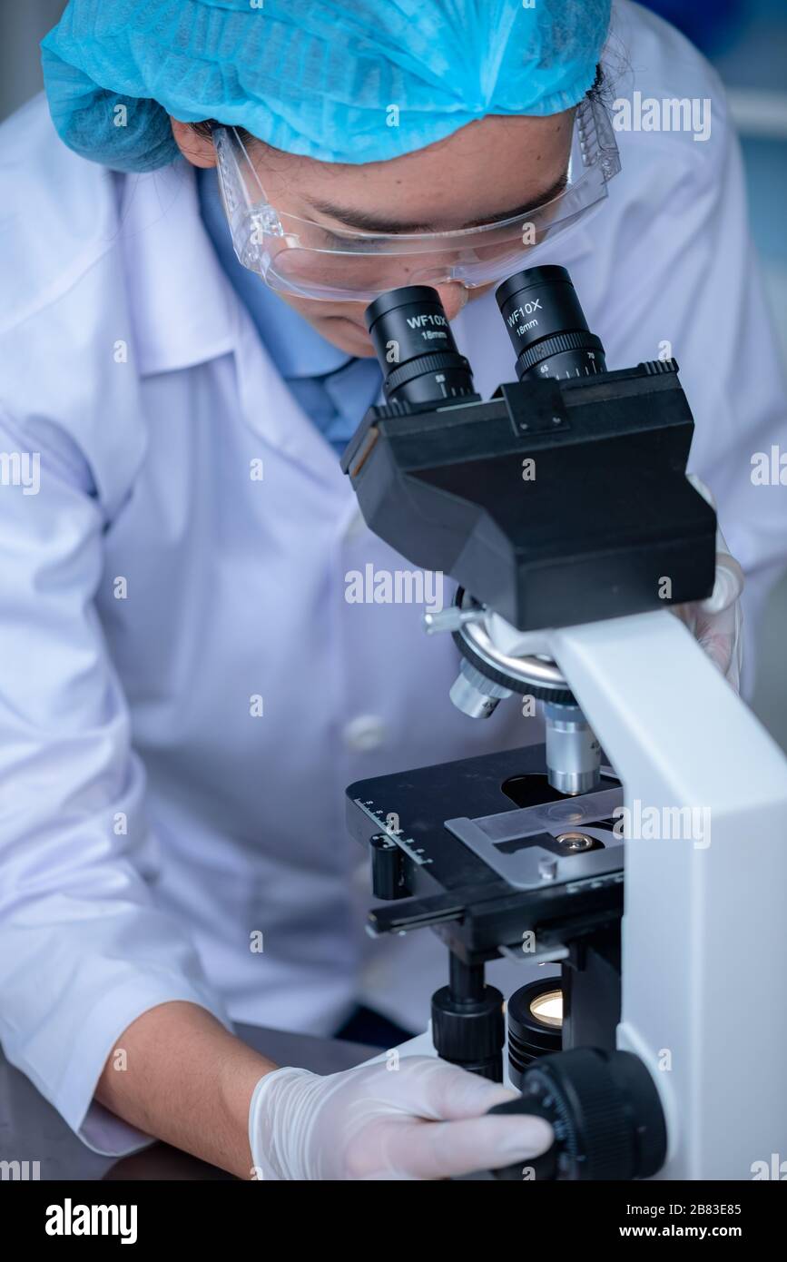 Young scientist looking through a microscope in a laboratory. Young ...