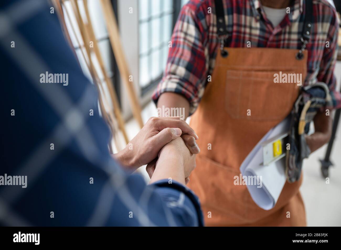 Two carpenters holding hands, The concept of working together until ...