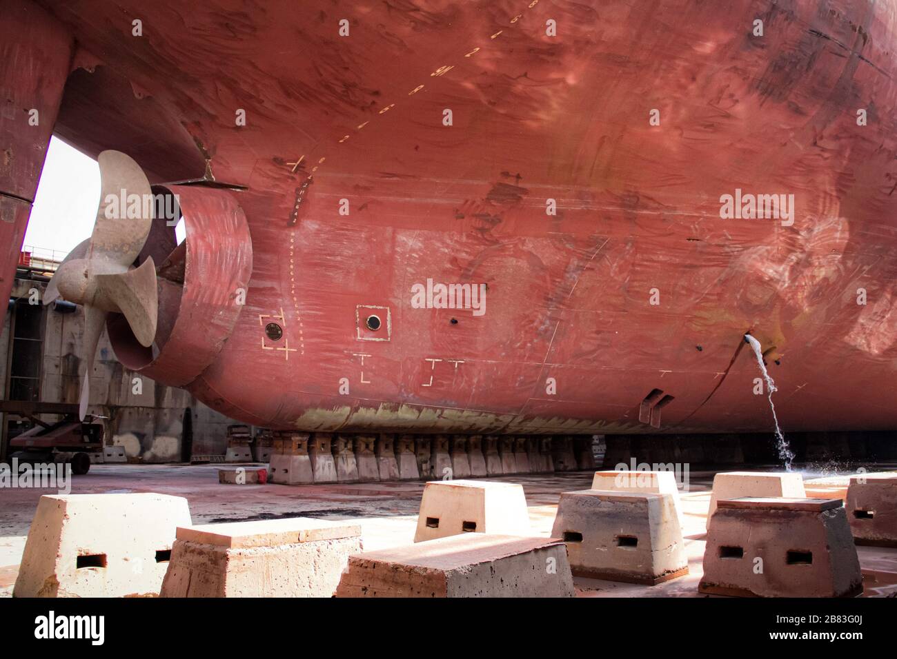A large tanker cargo ship is being renovated and painted in shipyard ...