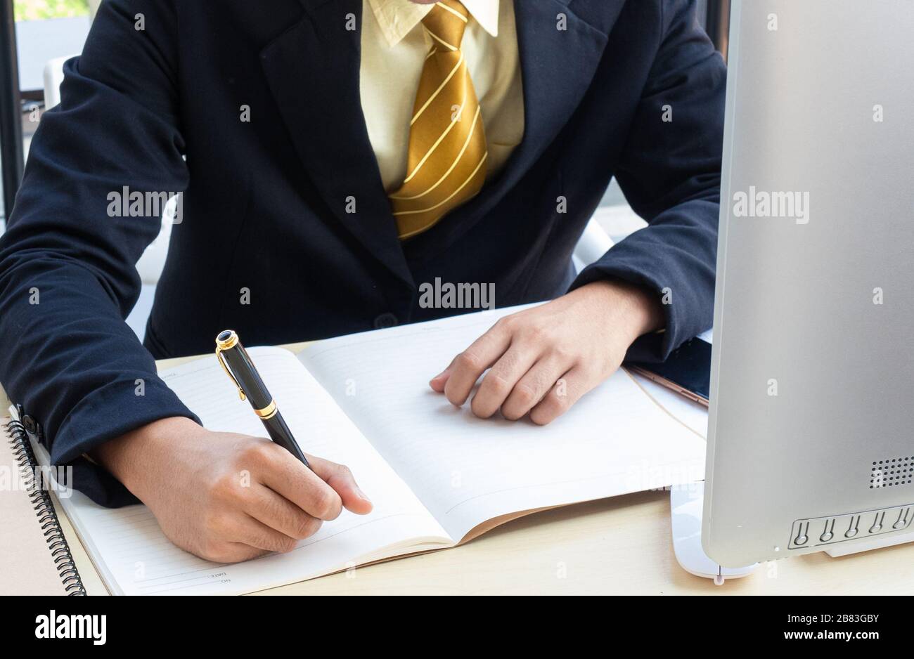 The executive is sitting on the desk, taking note of the creative ideas ...