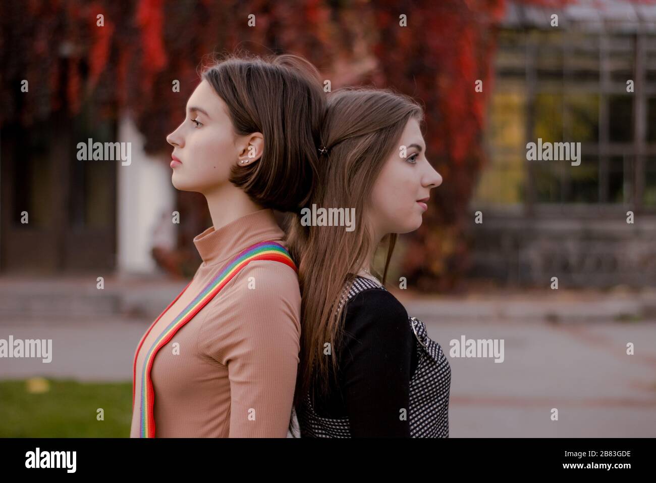 Lovely Sad girls stand back to back Stock Photo - Alamy