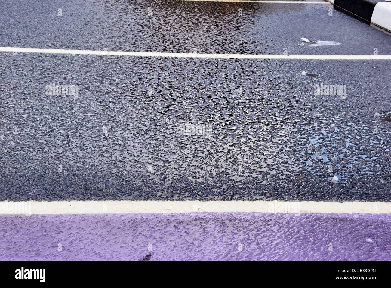 the ice is melting, spring is under the water wet asphalt and road ...