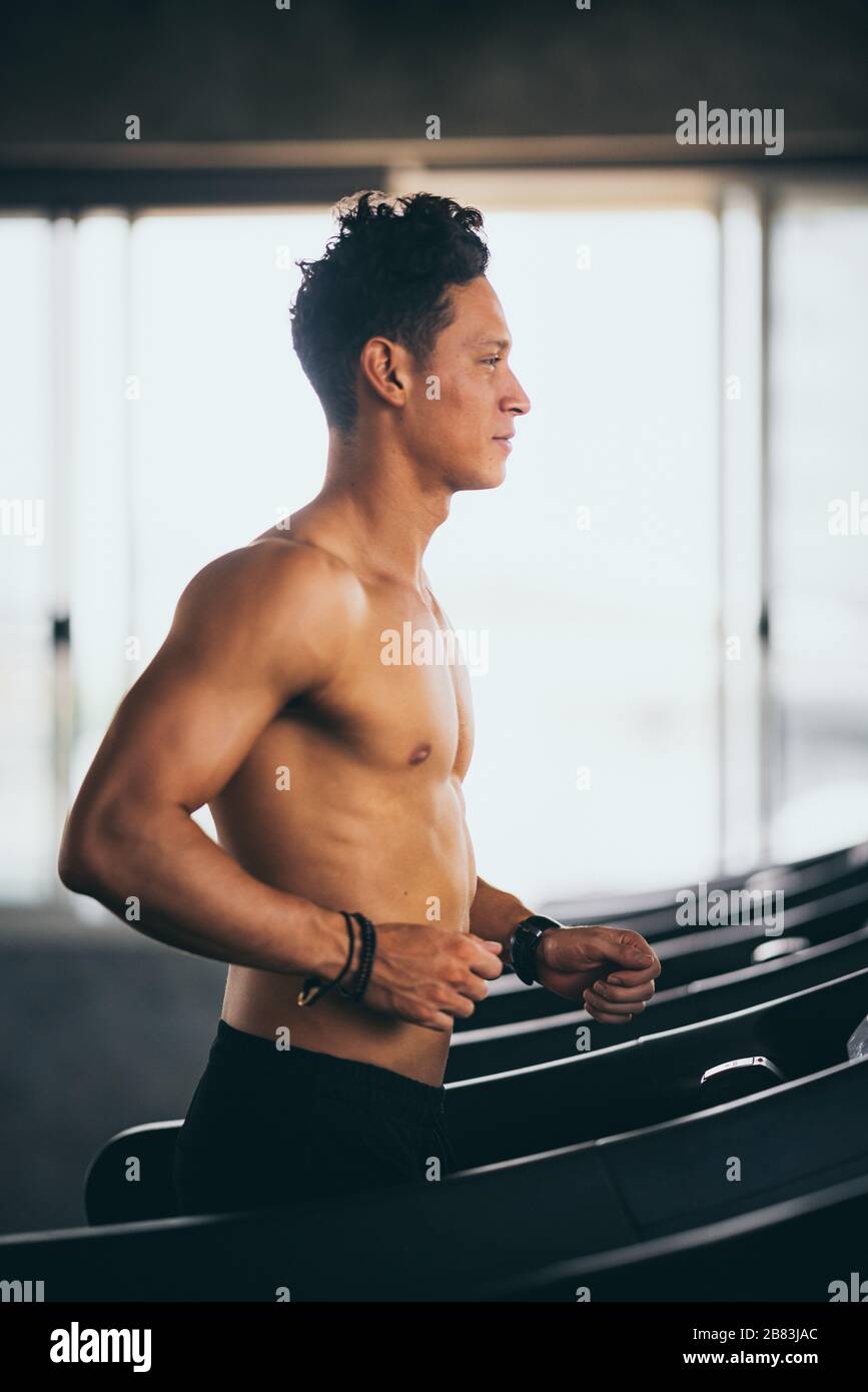 handsome man running on treadmill in fitness gym Stock Photo - Alamy