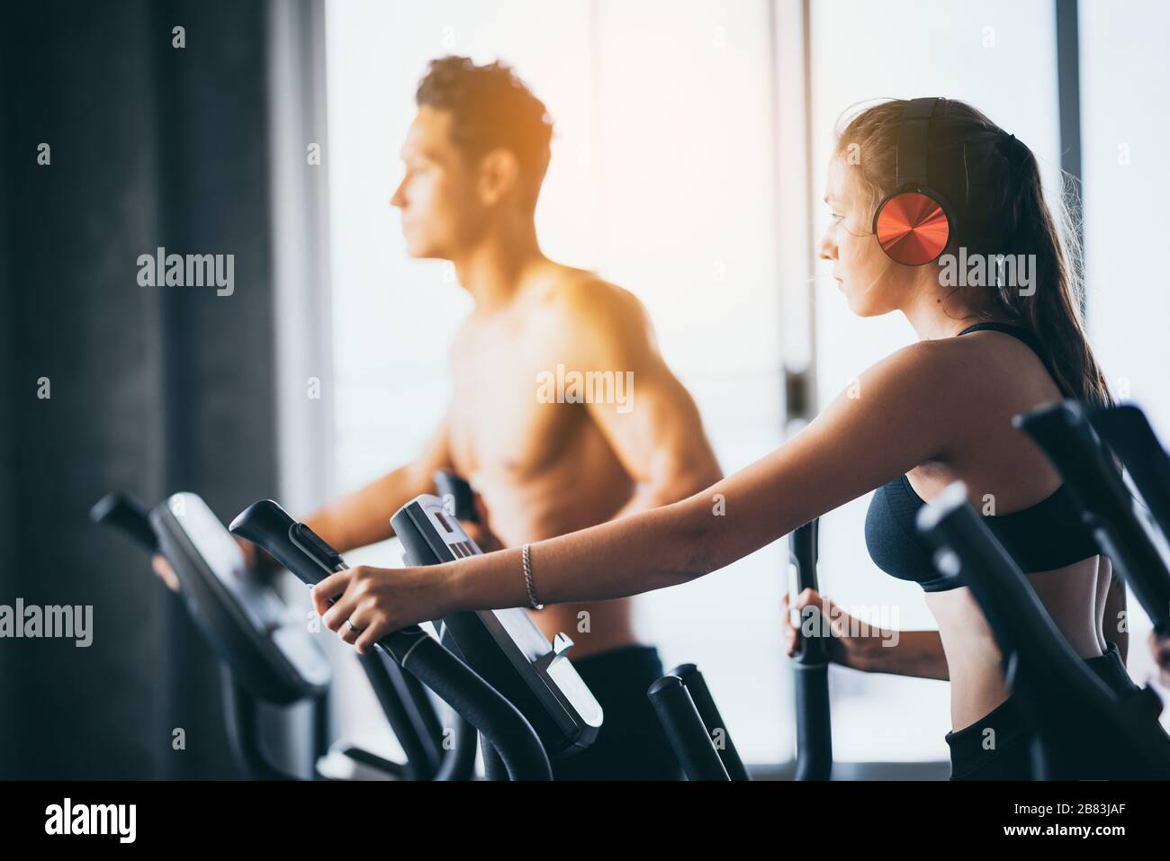 Young women wear headphones to exercise in the sport gym Stock Photo ...