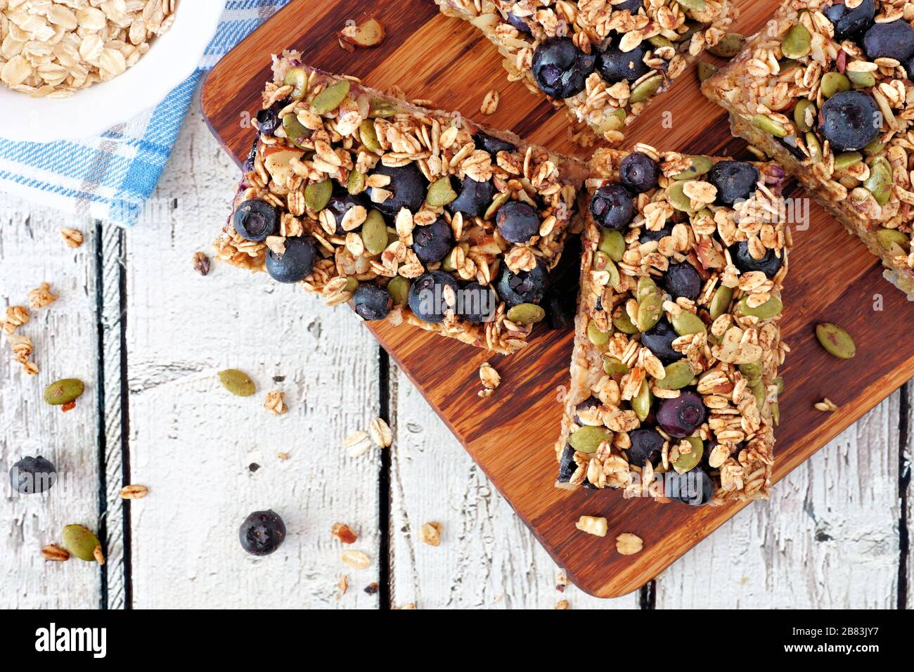 Superfood breakfast bars with oats and blueberries on wood board ...