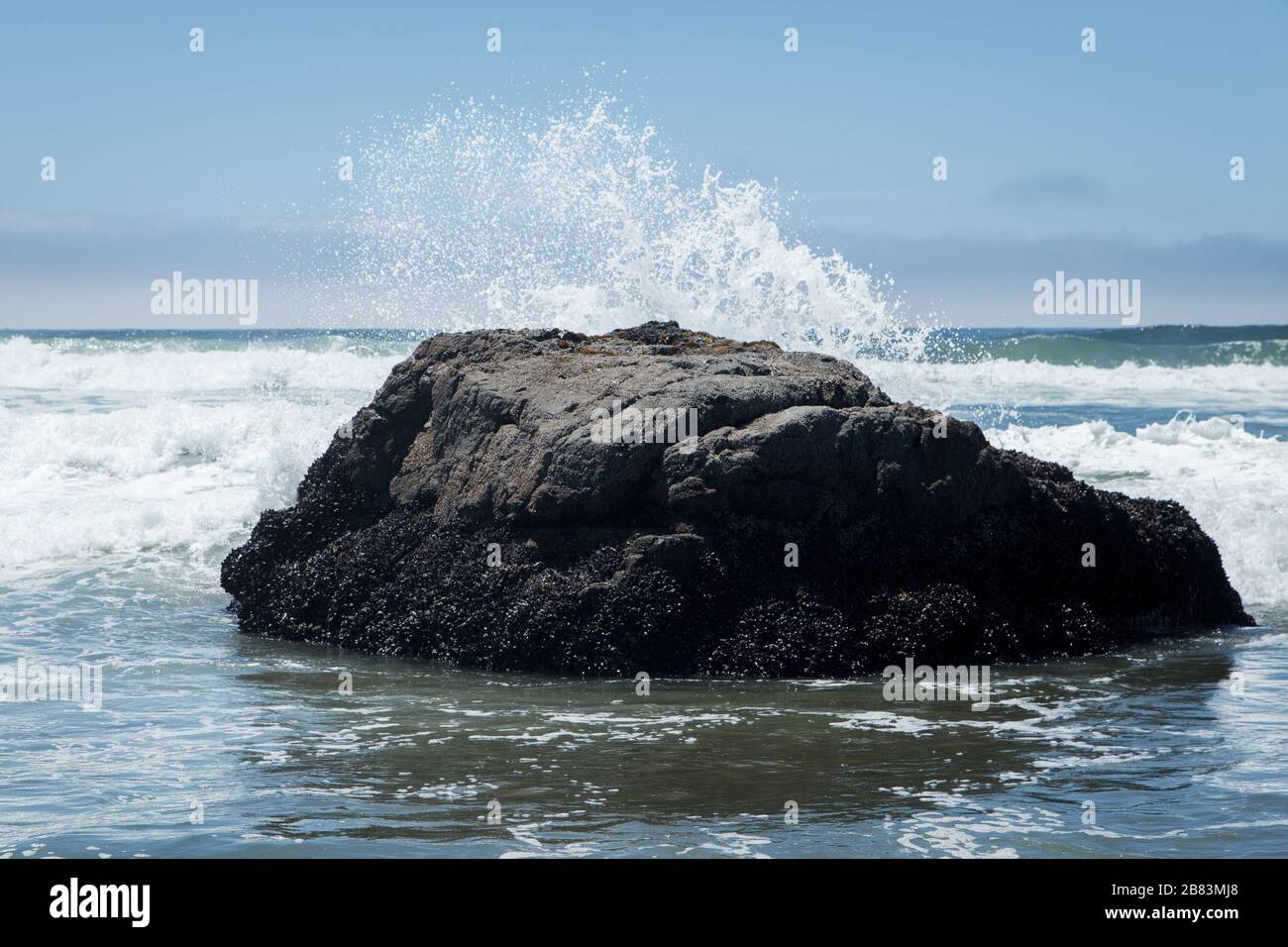 Large Black Rock at California Beach Coastline with Small Wave Spray ...
