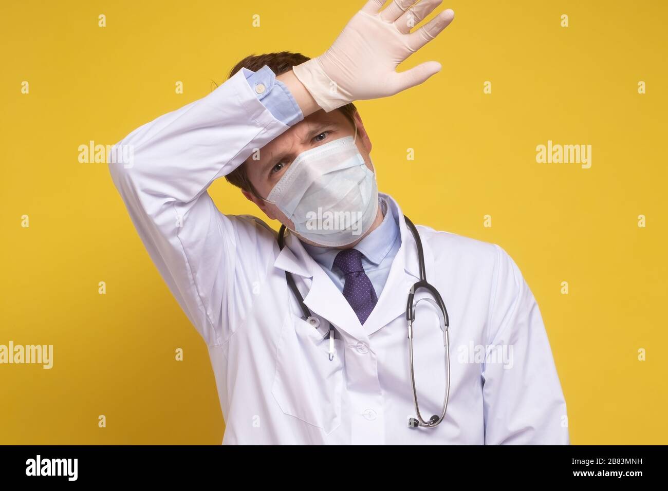 Caucasian man doctor looking stressed and tired after work against ...