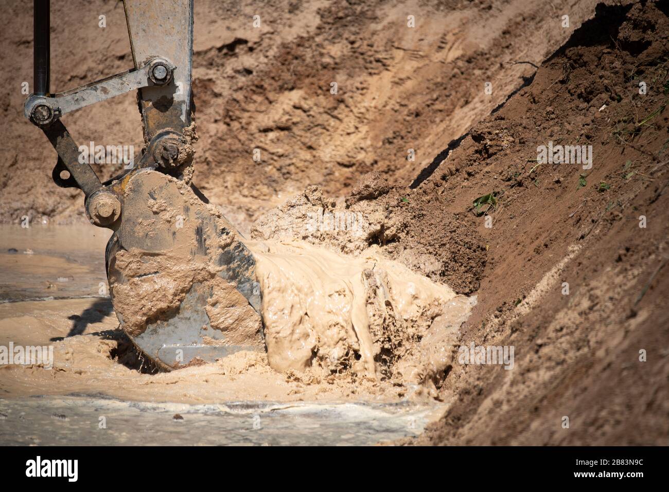 Excavator working with soil and water, during earthmoving works Stock ...