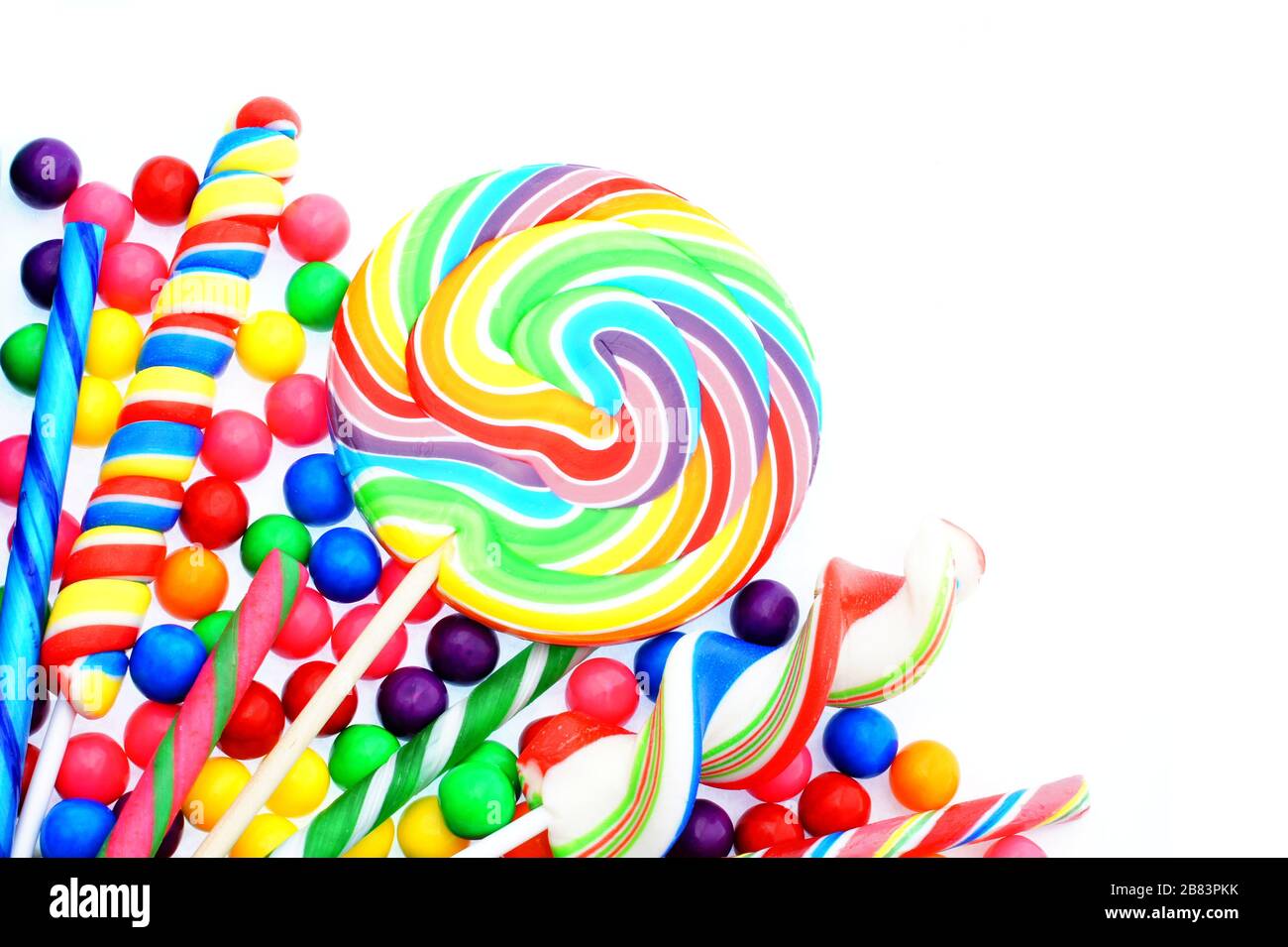 Colorful candy corner border with lollipops and gumballs over a white ...