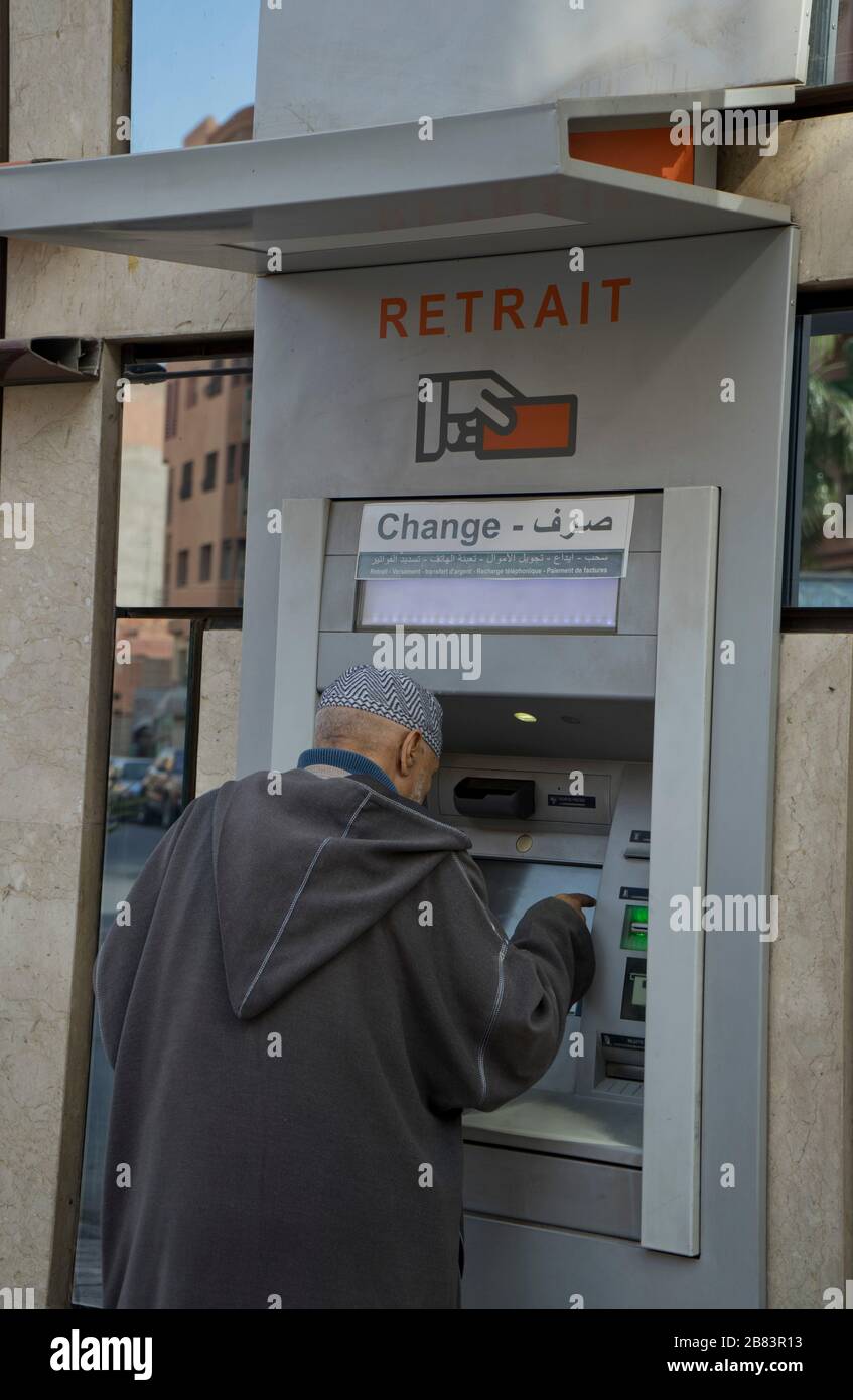 Customers withdrawing money at an ATM cash machine in a shopping centre ...
