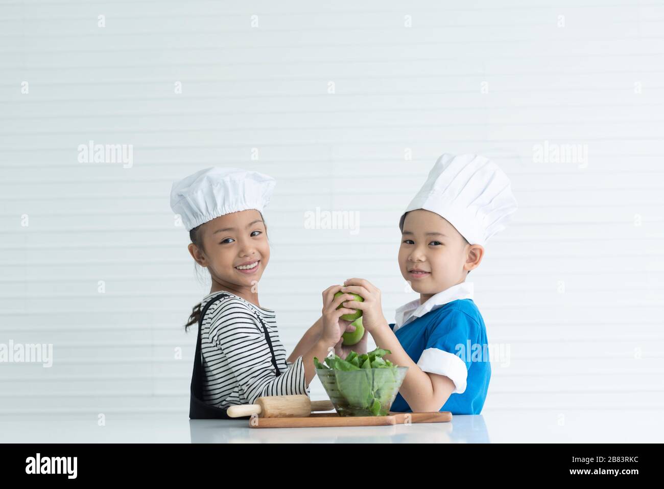 two children boy and girl in cooking and kitchen concept Stock Photo ...