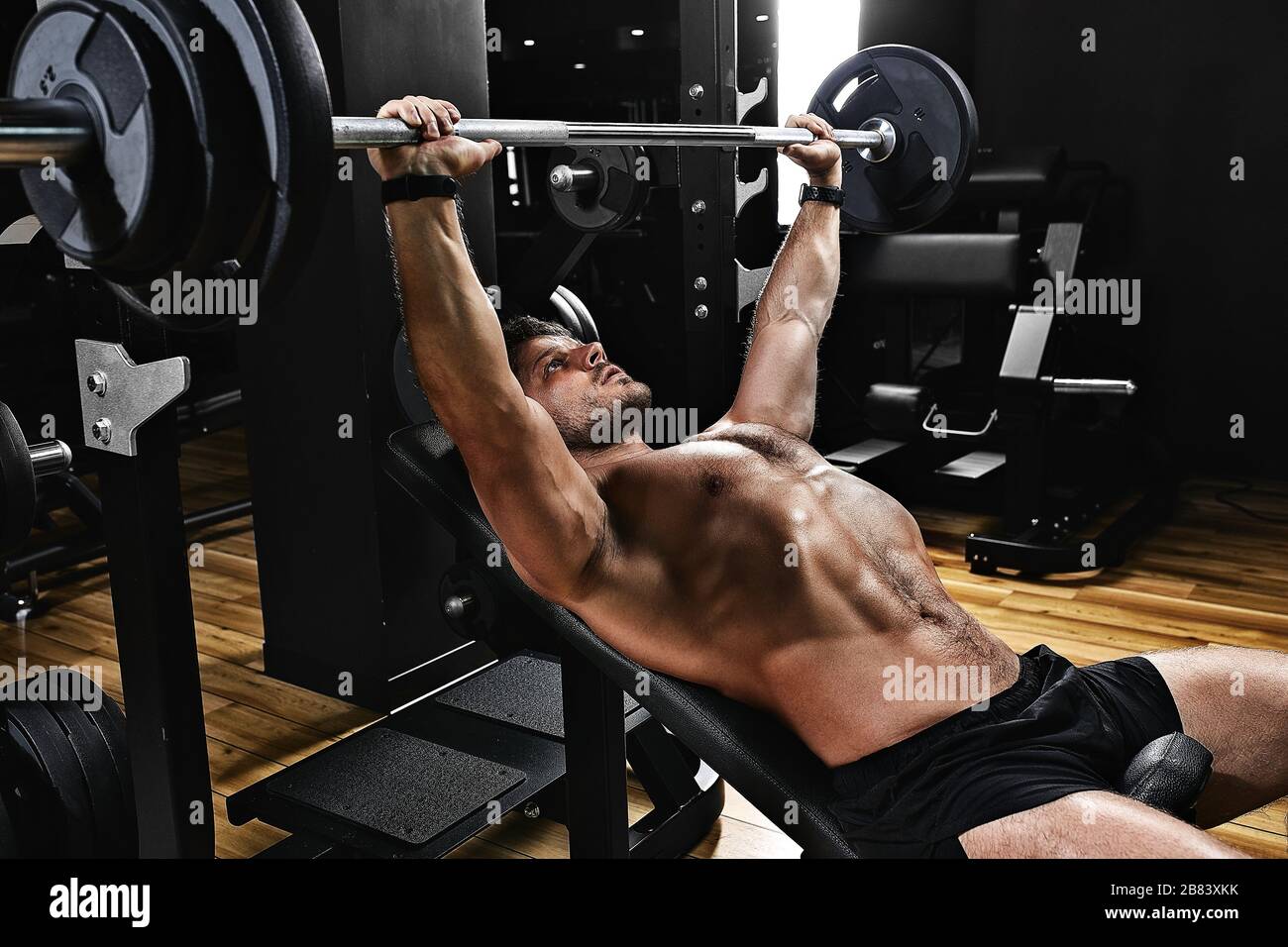 handsome young man doing bench press workout in gym, Fitness motivation ...