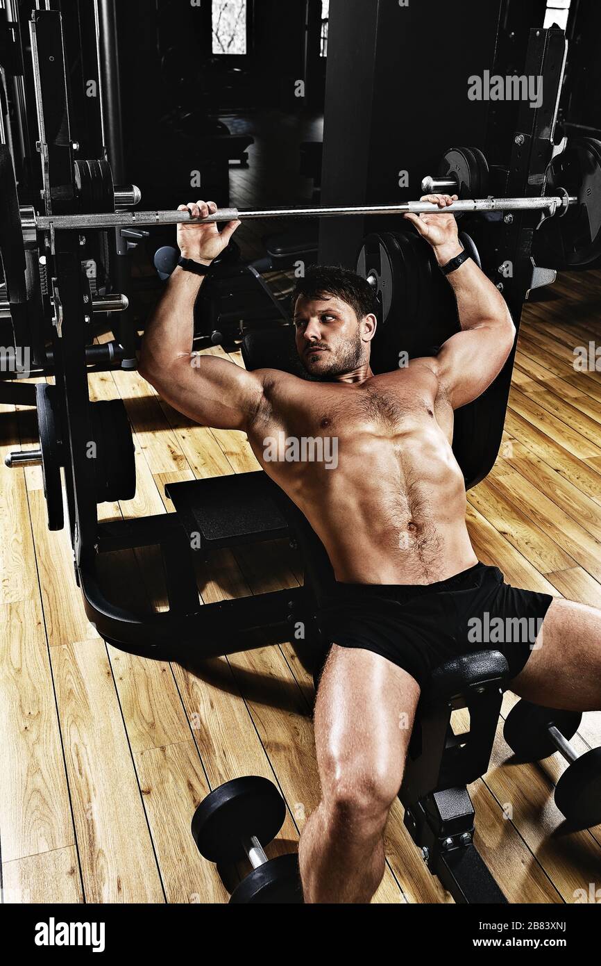 handsome young man doing bench press workout in gym, Fitness motivation ...