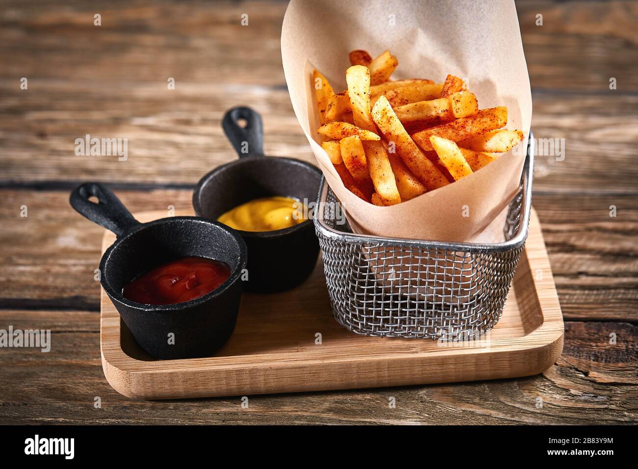 French fries with ketchup and mustard, wooden background, side dish ...