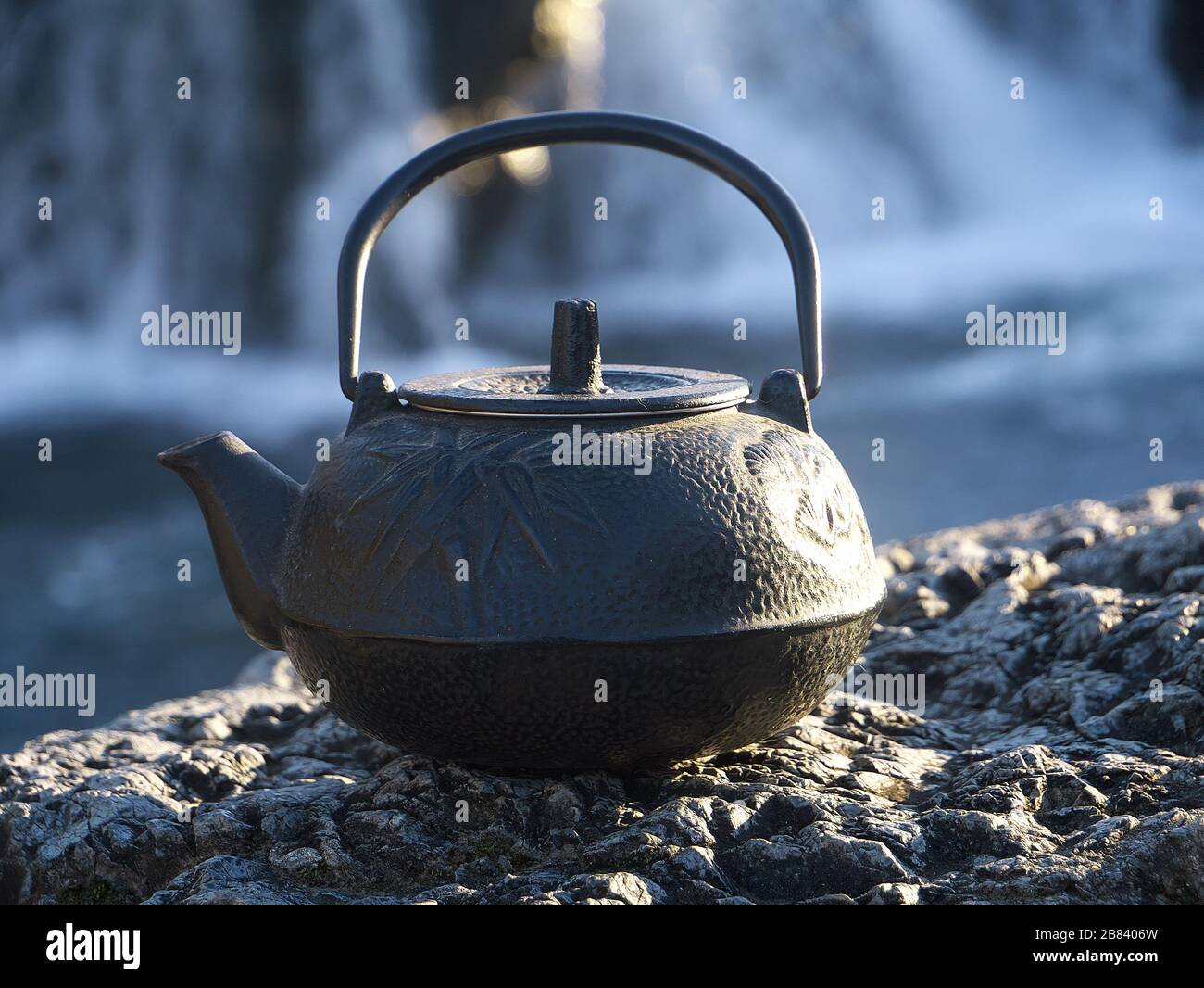 Brown iron cast teapot in front of a waterfall Stock Photo - Alamy