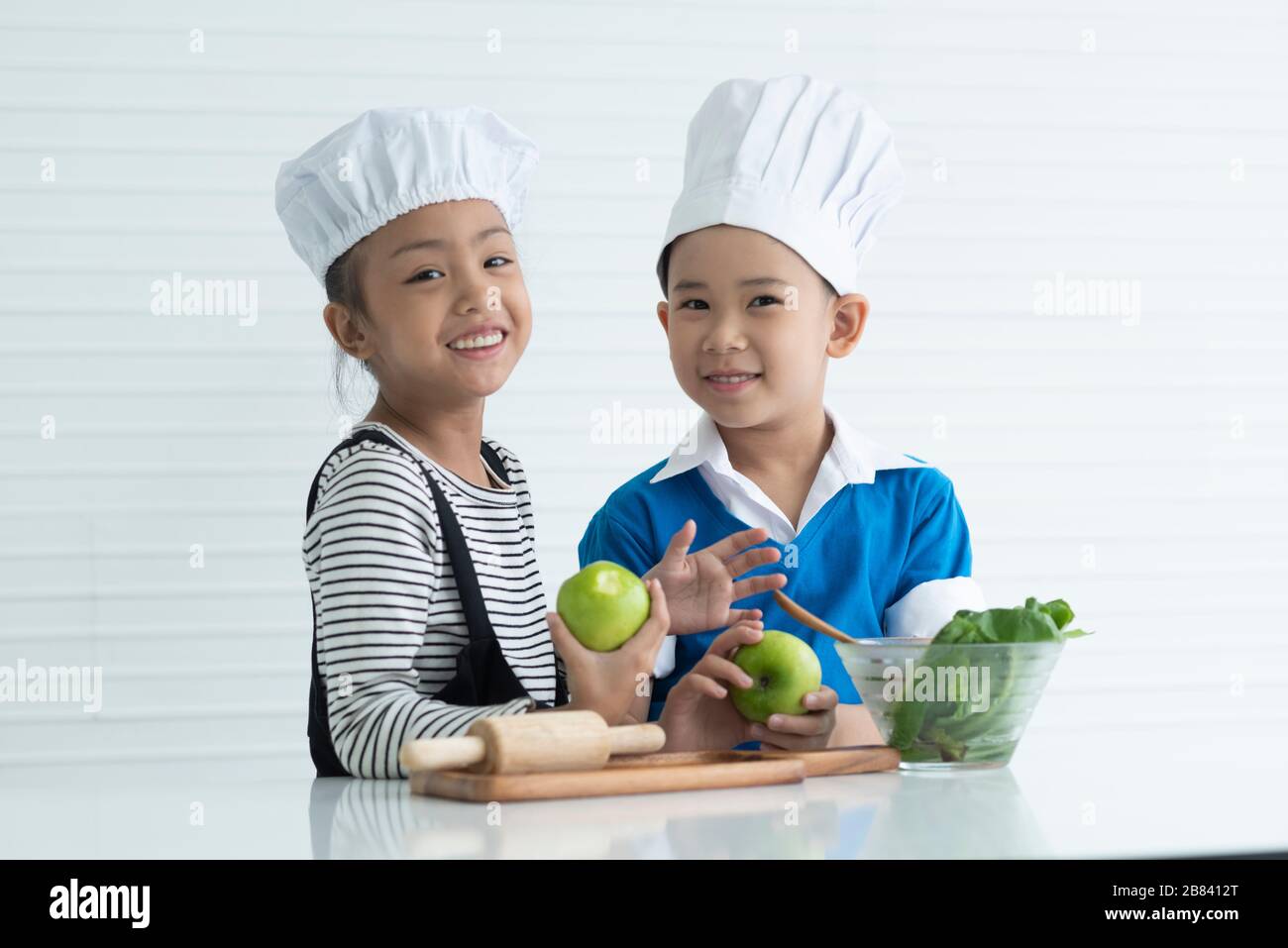 two children boy and girl in cooking and kitchen concept Stock Photo ...