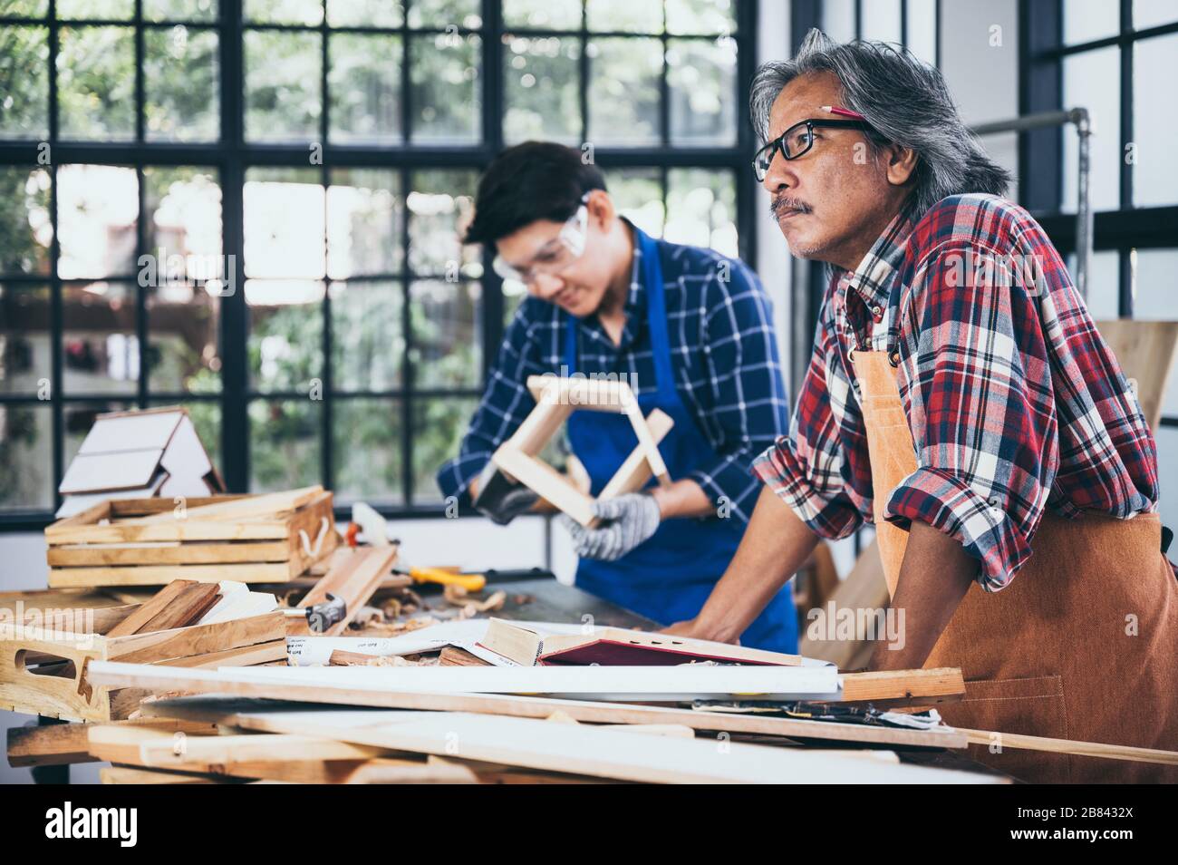 Two carpenters working in shop wood craftsman Stock Photo - Alamy