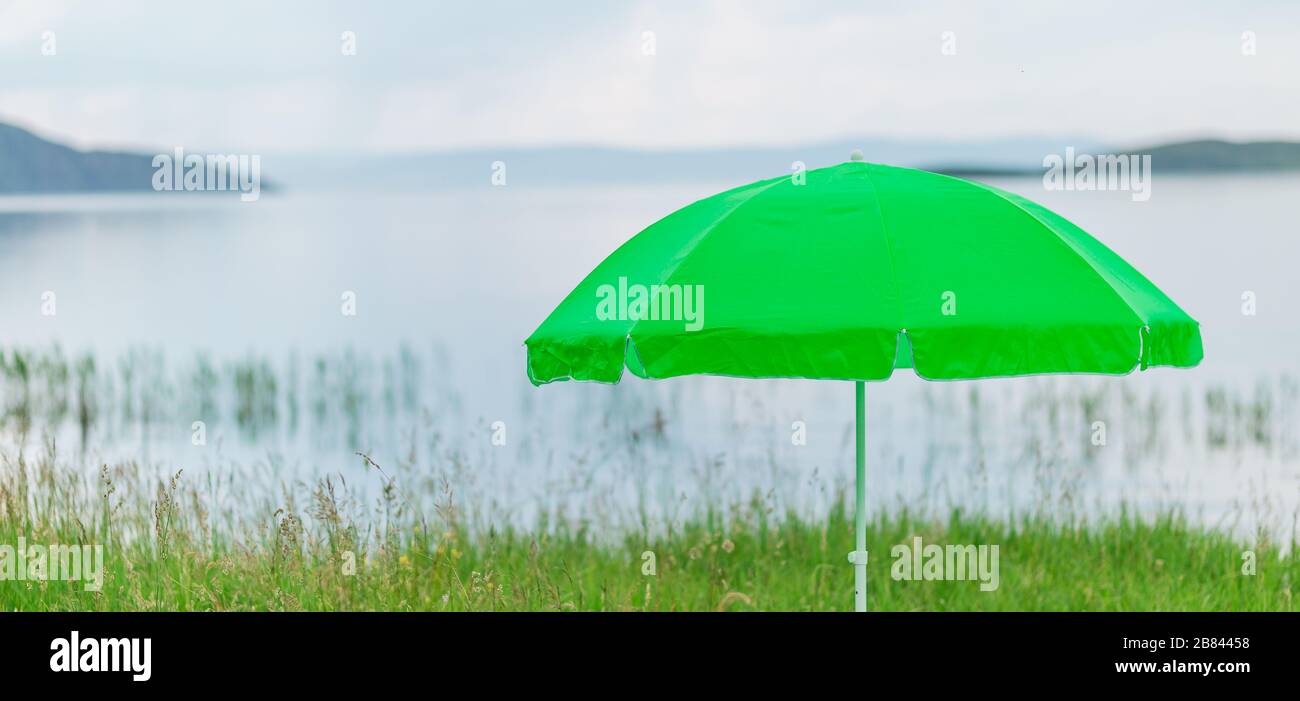 Modern green neon umbrella for sun on beach against sea Stock Photo - Alamy