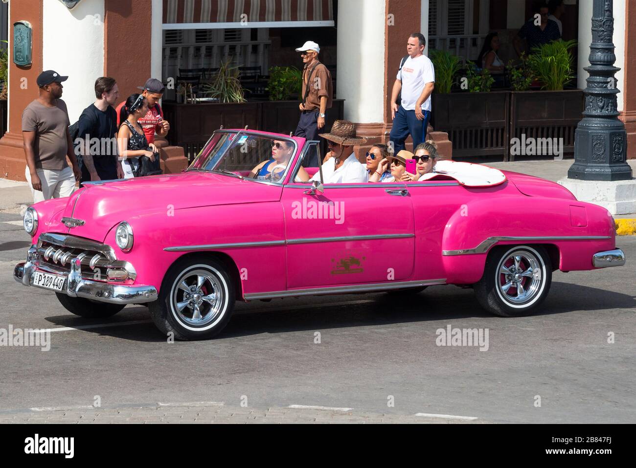 Women tourists in Havana, Cuba taking a ride in a classic pink ...