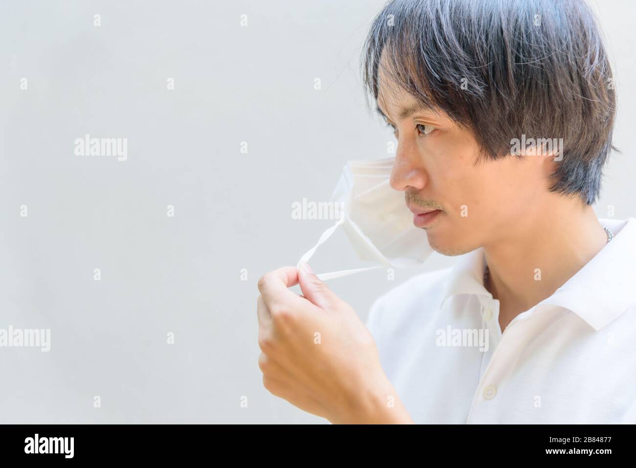 A asian man remove the N95 mask from his face Stock Photo - Alamy
