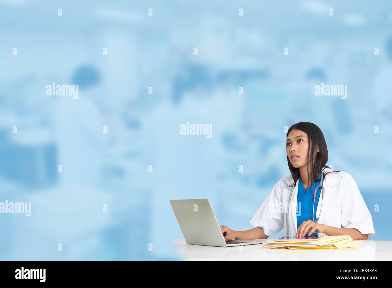 Female doctor working infront of blur blue background of medical ...