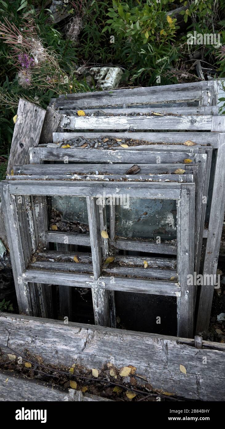 Old weathered rustic window frame. Ruin of an old wooden house which is ...