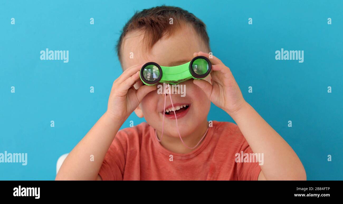 Kid looking through toy binoculars Stock Photo - Alamy