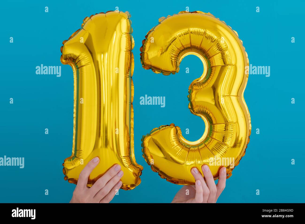 Gold foil number 13 celebration balloon Stock Photo - Alamy