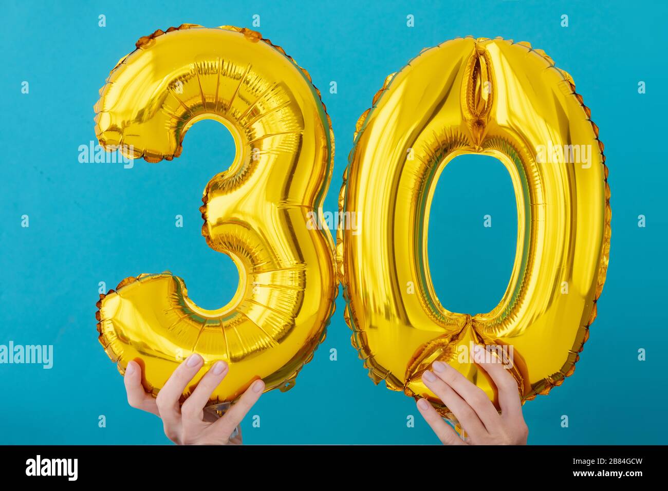 Gold foil number 30 thirty celebration balloon Stock Photo - Alamy