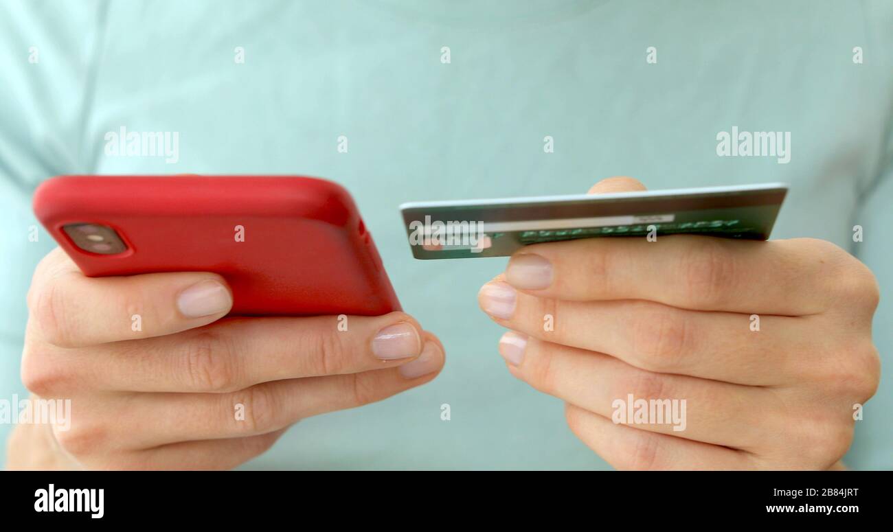 Womans hands holding a credit card and using cell phone Stock Photo - Alamy