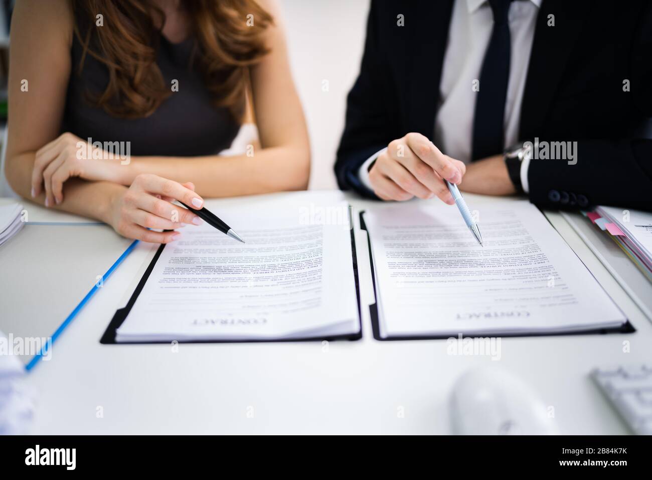Close-up Of Two Businesspeople Hand Working On Contract Paper Over Desk ...