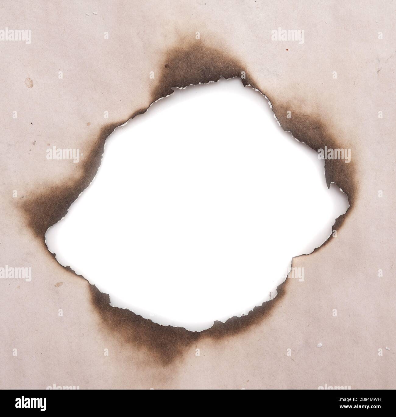 Burnt hole in a paper isolated on white background Stock Photo - Alamy