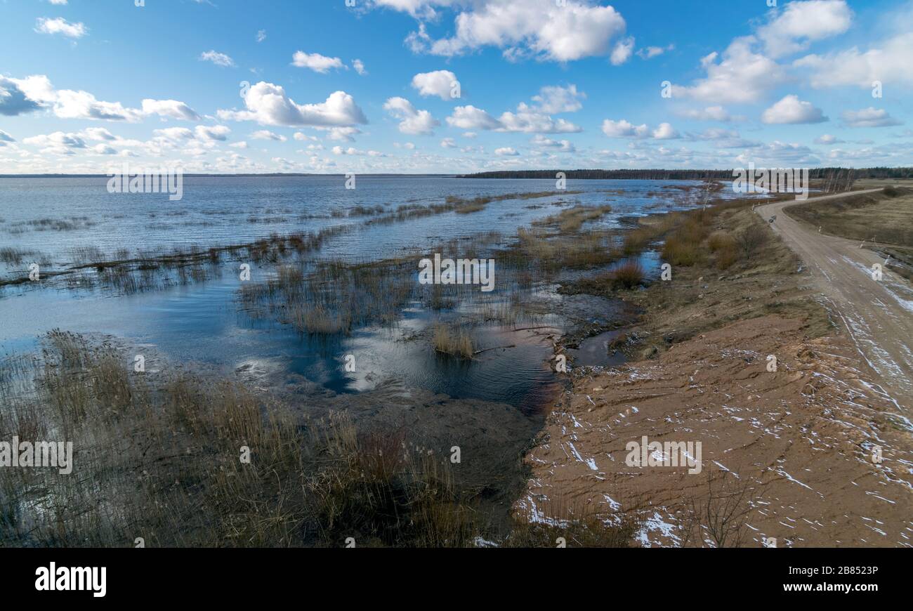landscape with a flooded lake in spring, the path to the beach ends in ...