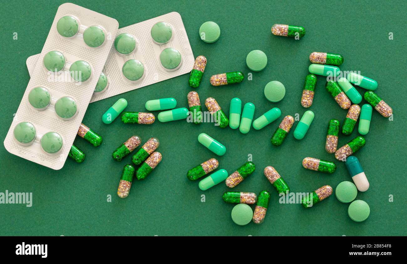 Medicine pills and capsules on green background. Variation of pharmacy ...
